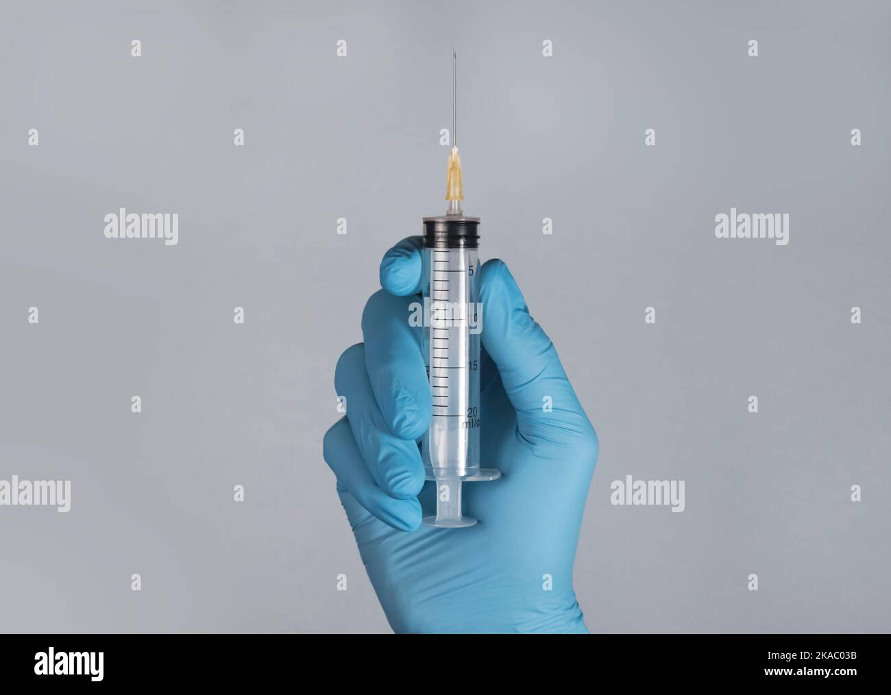 Syringe with needle in doctors hands in glove Stock Photo - Alamy