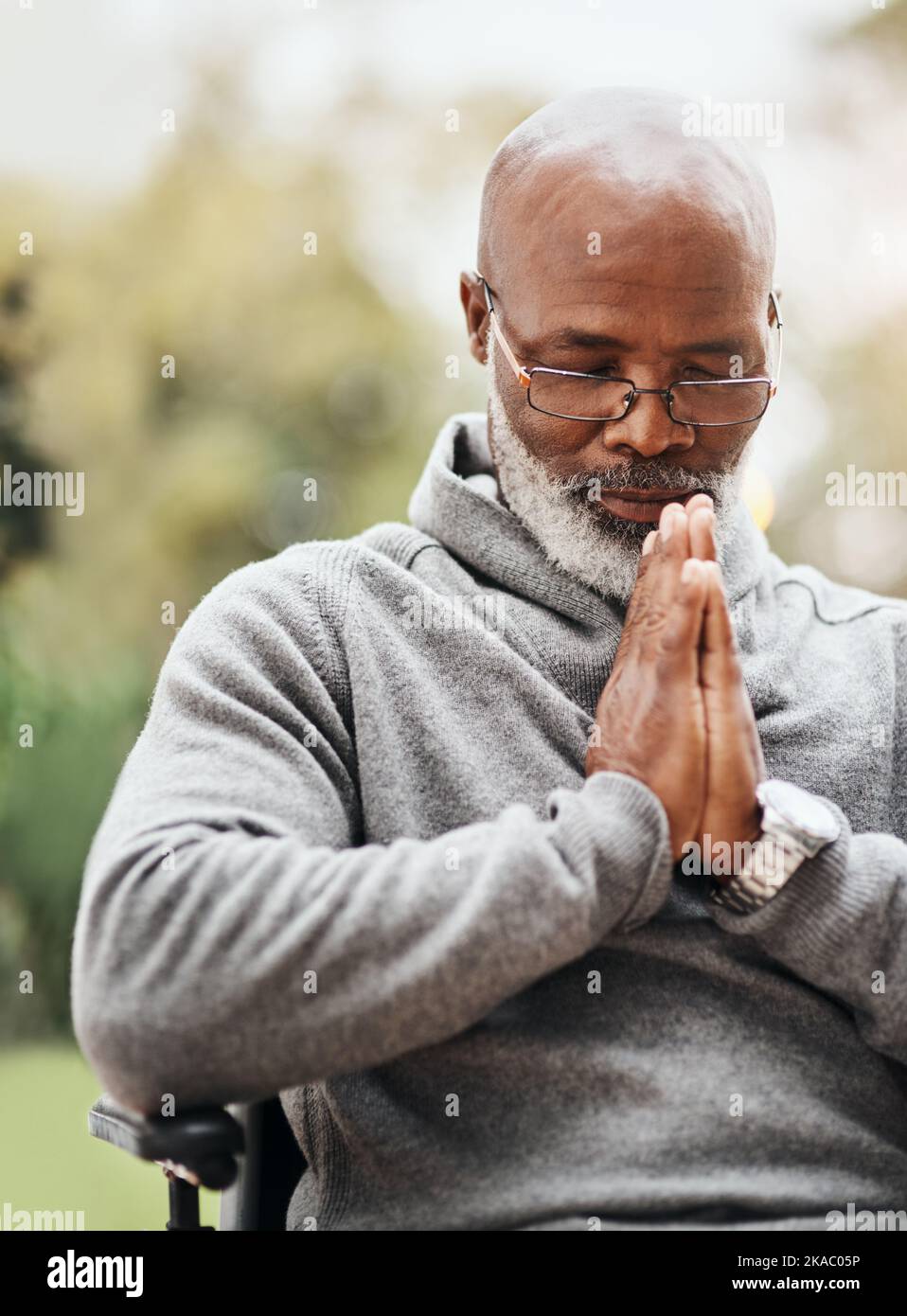 Hes praying for a sign from above. a senior man holding his hands ...