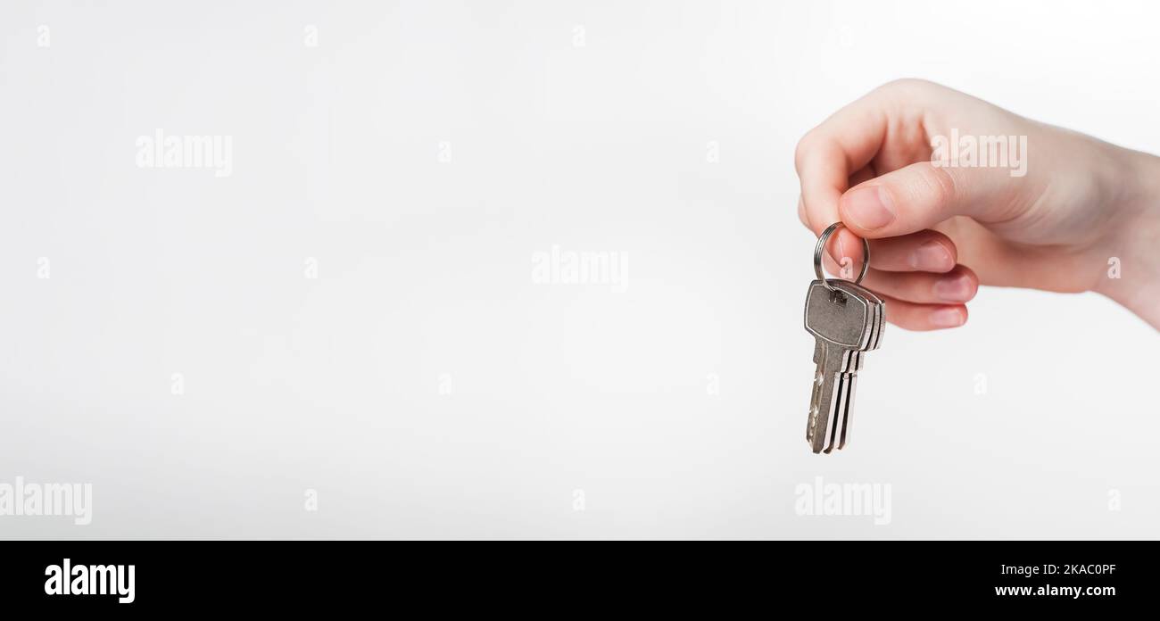 Hand holding keys on keyring over white background. Promo banner for ...