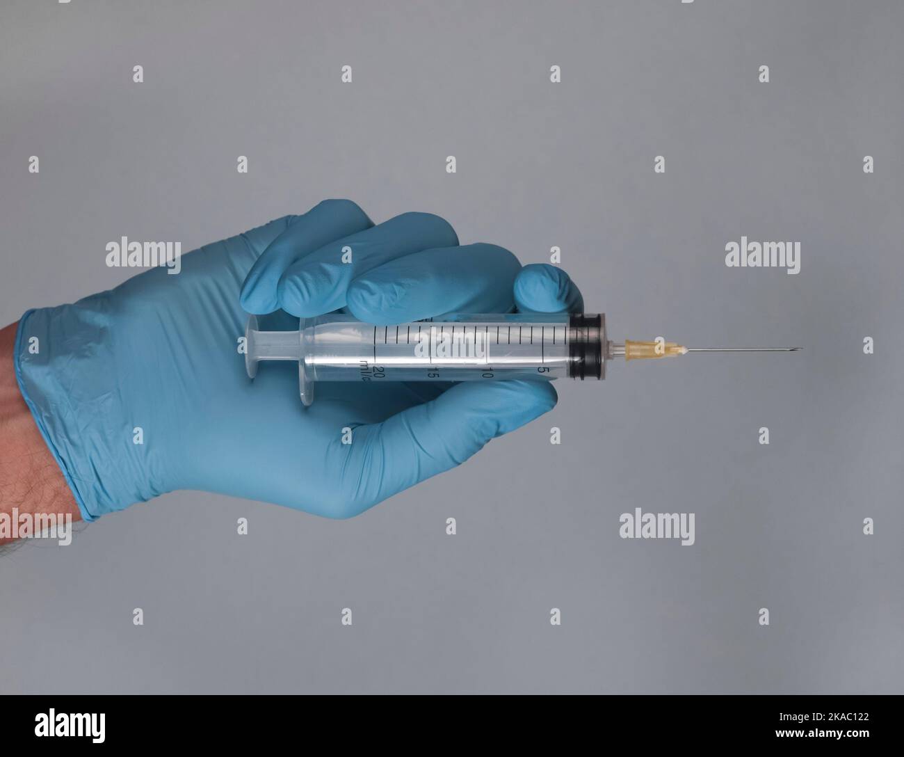 Syringe with needle in doctors hands in glove Stock Photo - Alamy