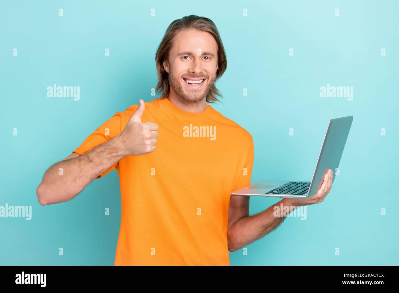 Photo of young bearded handsome programmer funny man showing thumb up like new software for his ...