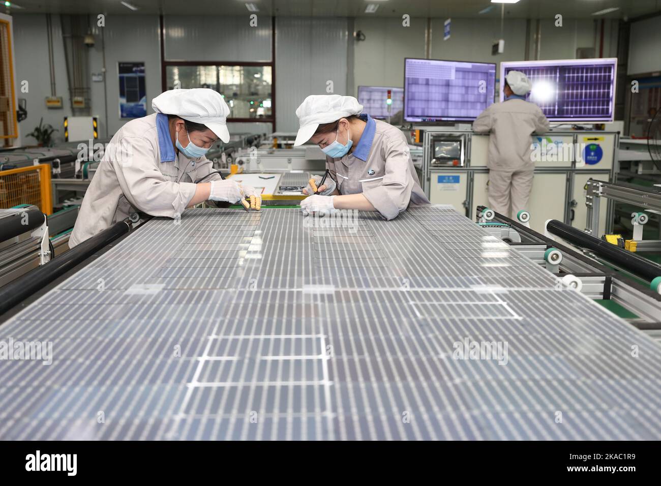 Workers are busy manufacturing the export solar photovoltaic panels in ...