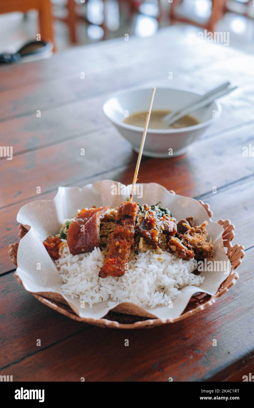 A plate of Nasi Babi Guling or Pork Roll Rice in English which typical ...