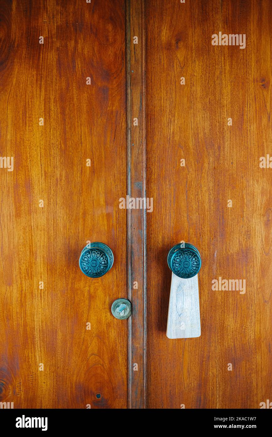 Traditional wooden door with two steel handles in a resort in Ubud ...