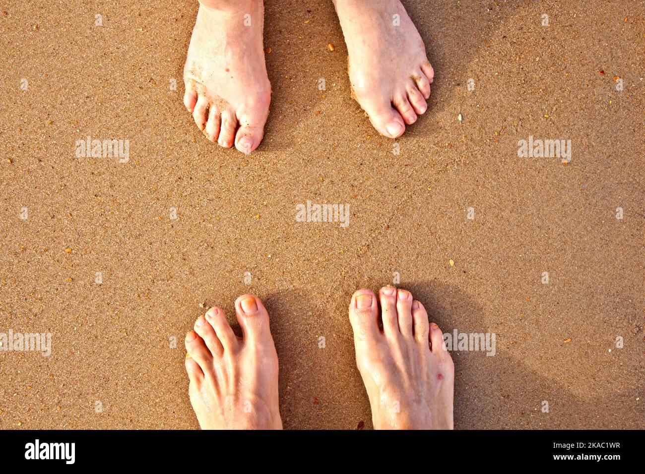 feet of a couple at the sandy beach Stock Photo - Alamy