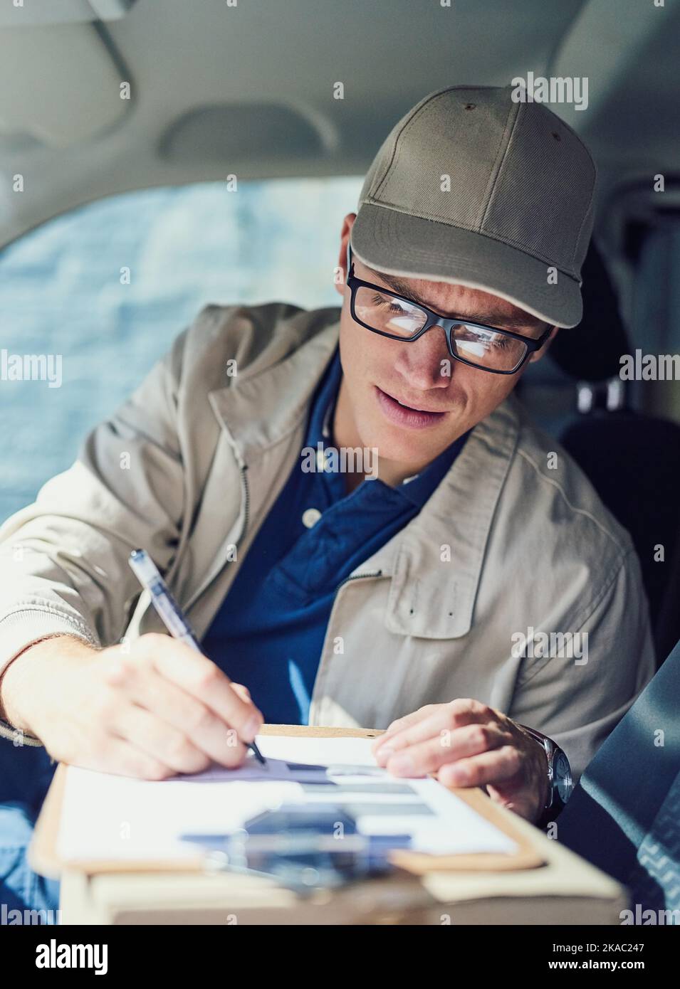 Its all about the logistics. a courier writing on a clipboard while ...