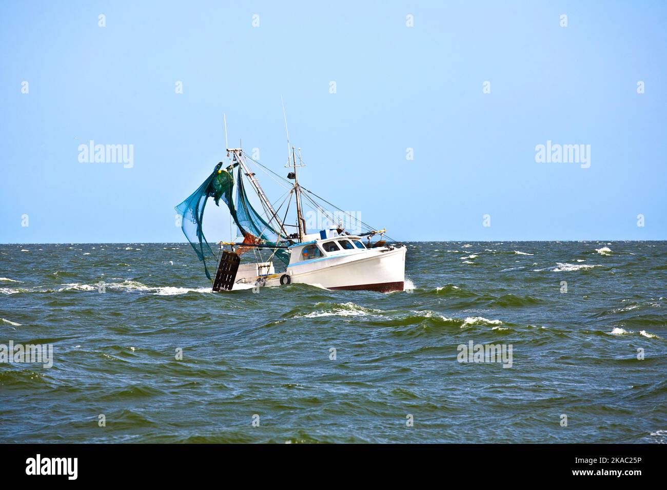 small fishing boat heading out to the ocean in late afternoon Stock ...