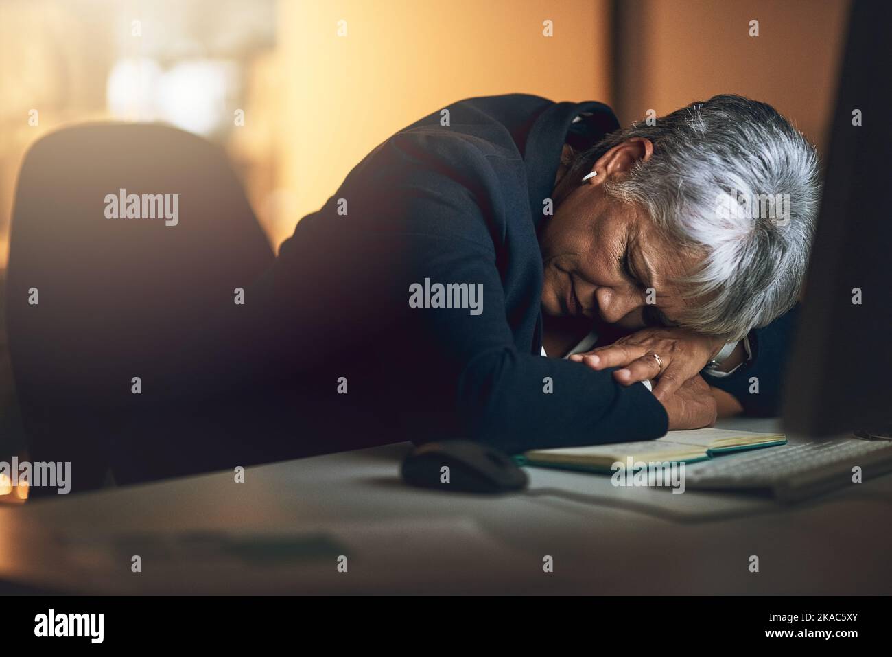 We all have a limit. a mature businesswoman sleeping at her desk during ...