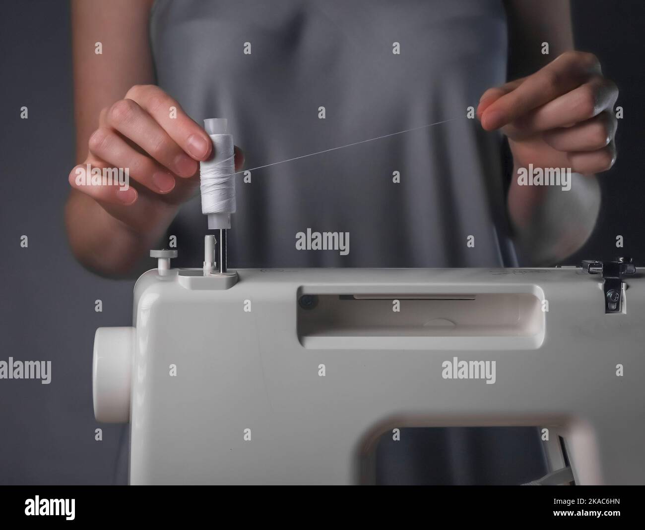 Seamstress hands putting thread spool on sewing machine close up Stock ...