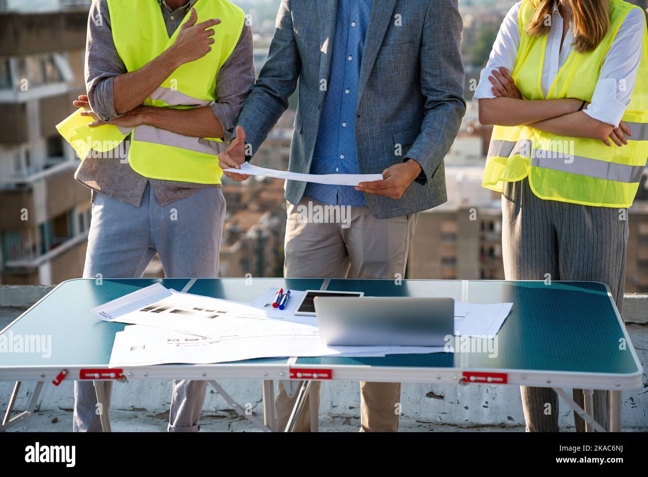 Diverse team of specialists with computer on construction site ...