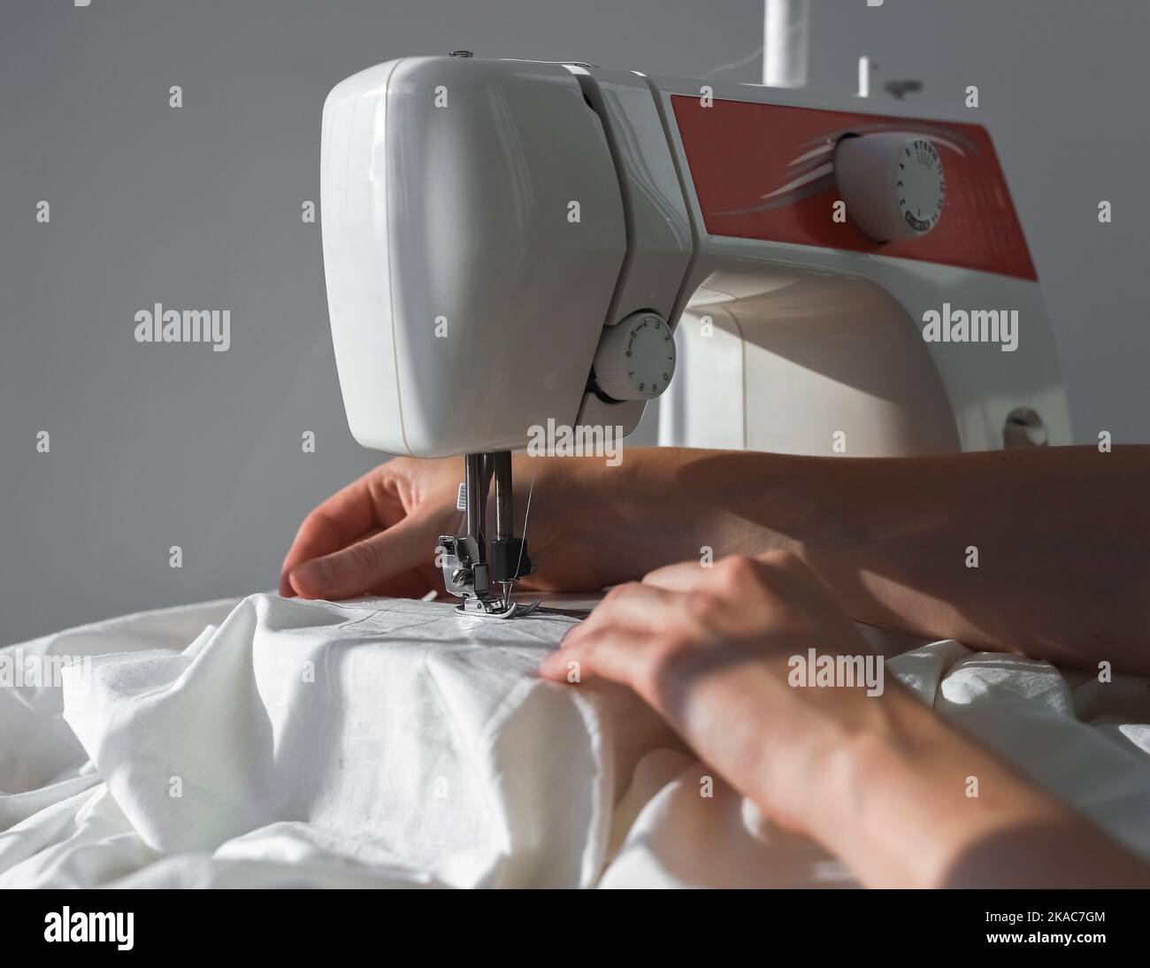 Hands with white cotton cloth work at sewing machine, Working process ...