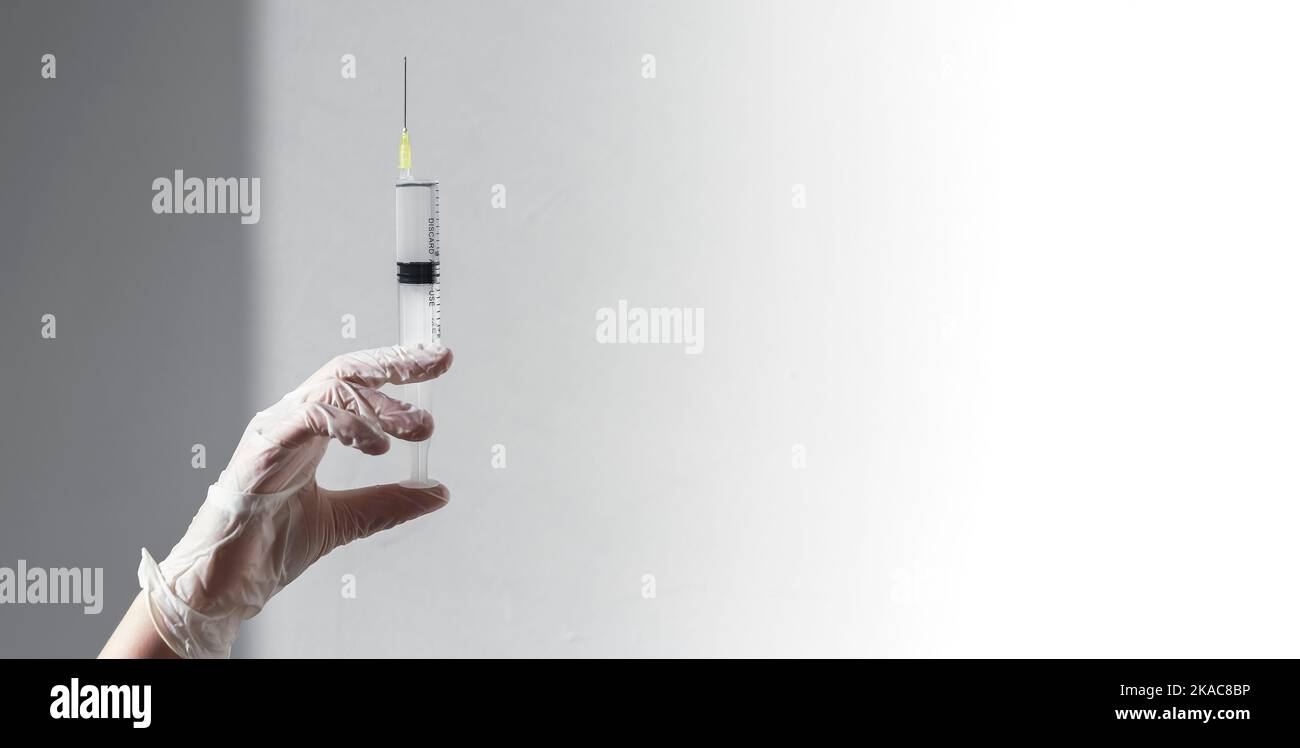 Syringe with needle in hand on white background with copy space for ...