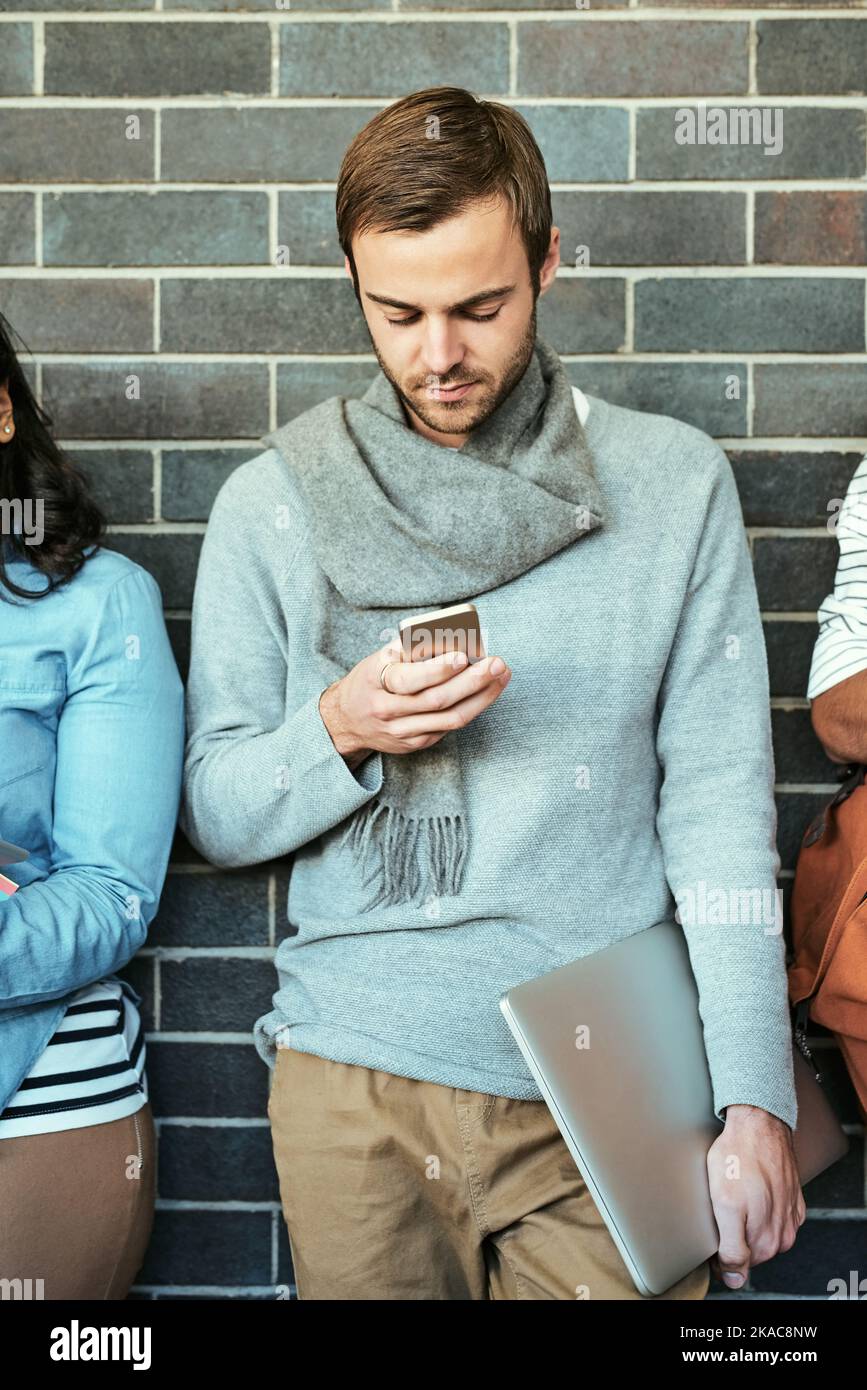 Checking his messages before class. a handsome young male university ...