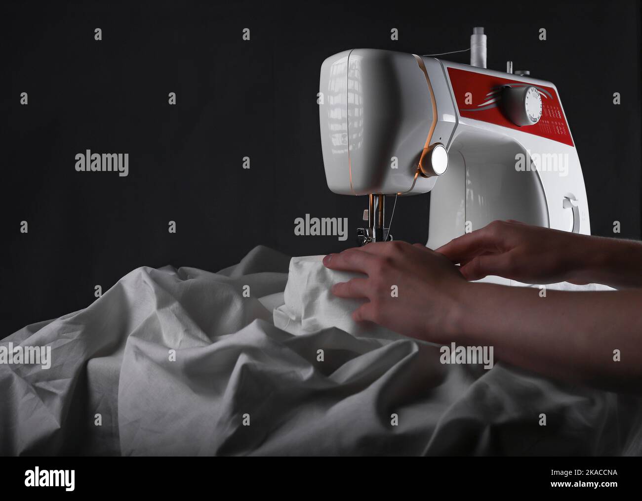 Hand at sewing machine during working process with textile Stock Photo ...