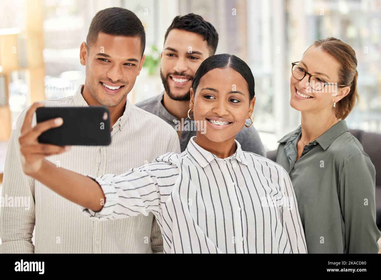 Business people taking team selfie for social media on smartphone ...