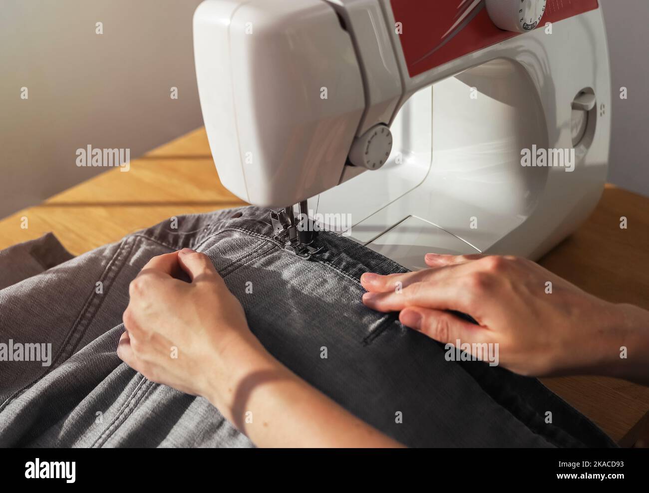 Denim cloth on sewing machine closeup. Seamstress work process concept ...