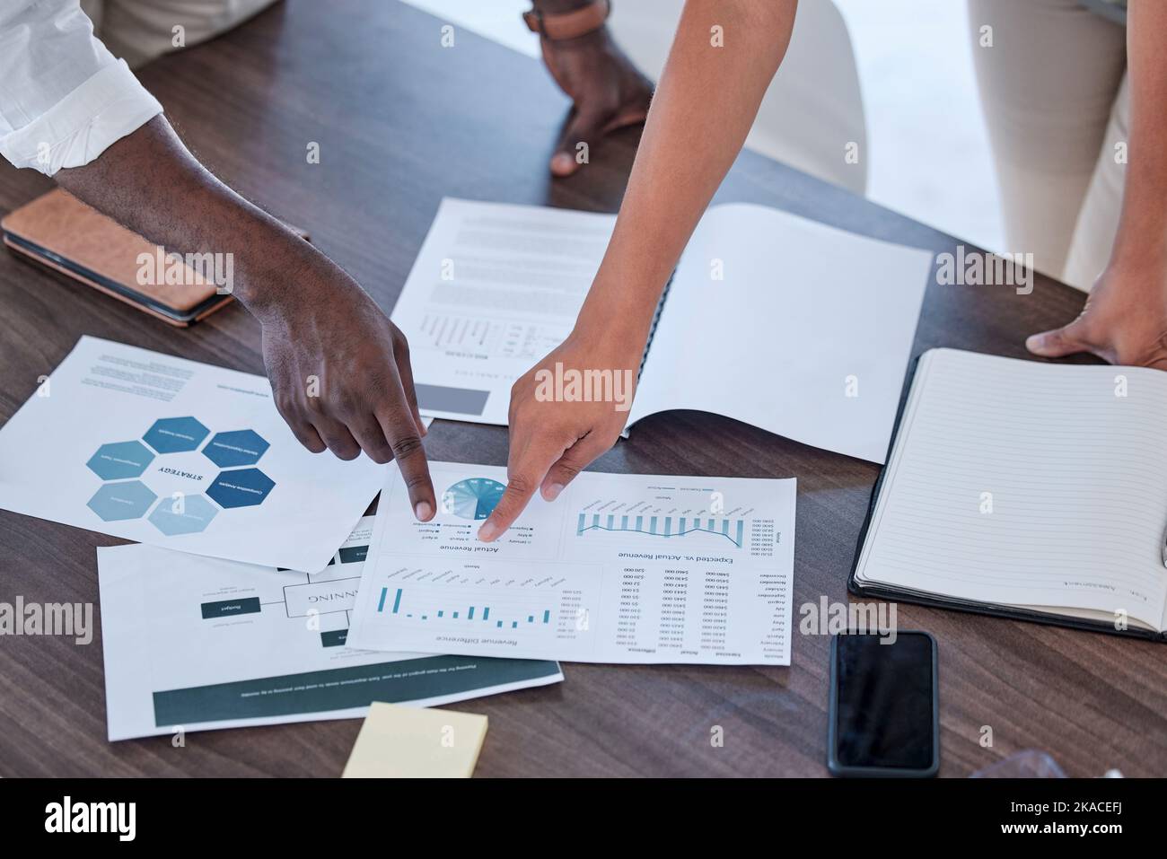 Hands of diversity business people pointing at documents, chart data or ...