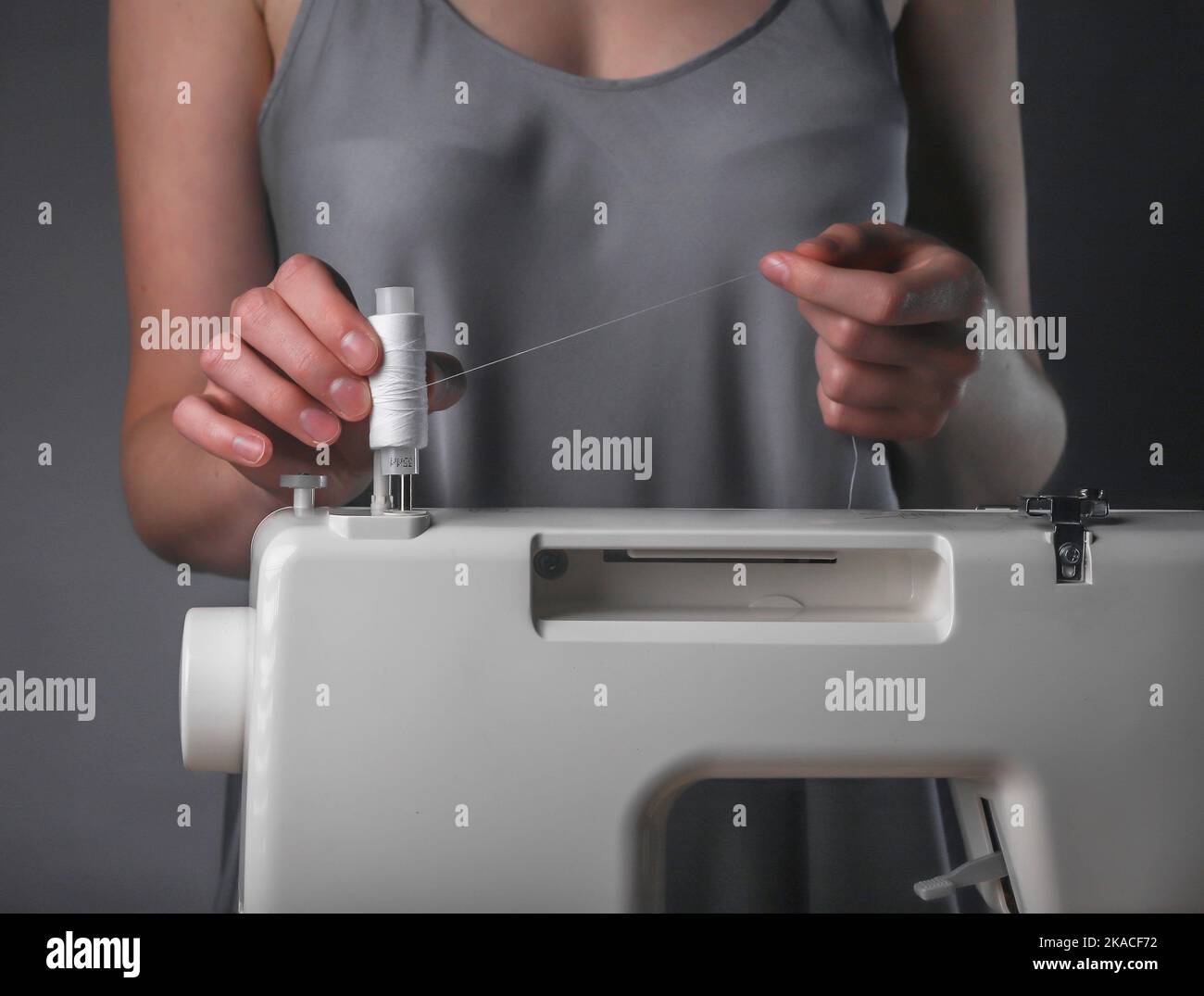 Hands putting thread spool on sewing machine, starting her work Stock ...