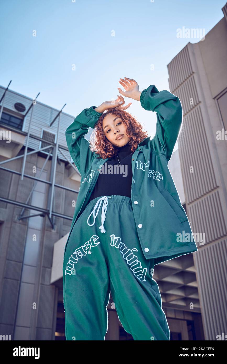City, urban fashion and gen z black woman in streetwear with buildings ...