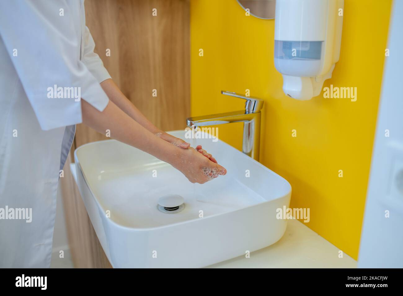 Female doctor washing hands in the bathroom Stock Photo - Alamy
