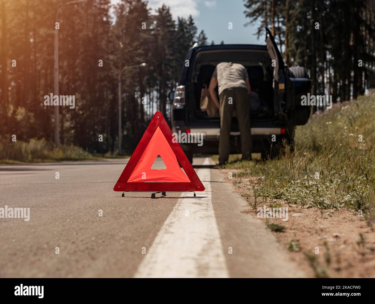 Red and orange bright riangle caution sign on road after car breakdown ...