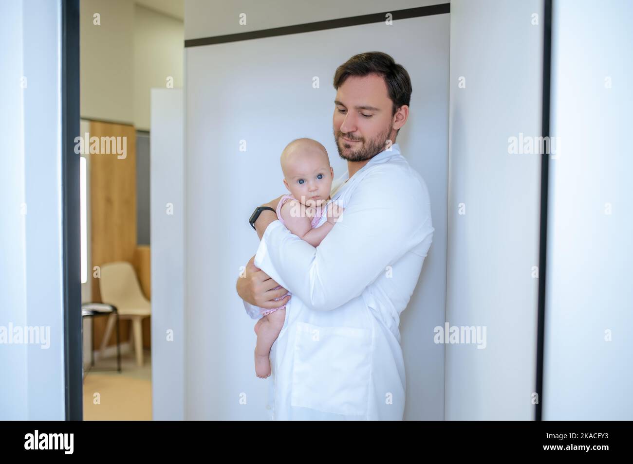 Bearded pediatrician holding a cute baby Stock Photo - Alamy