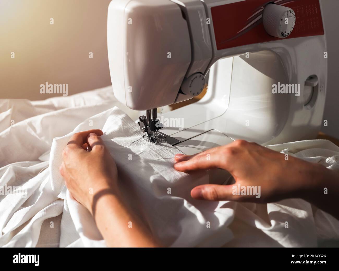 Women hands with natural cotton cloth. Work process at sewing machine ...