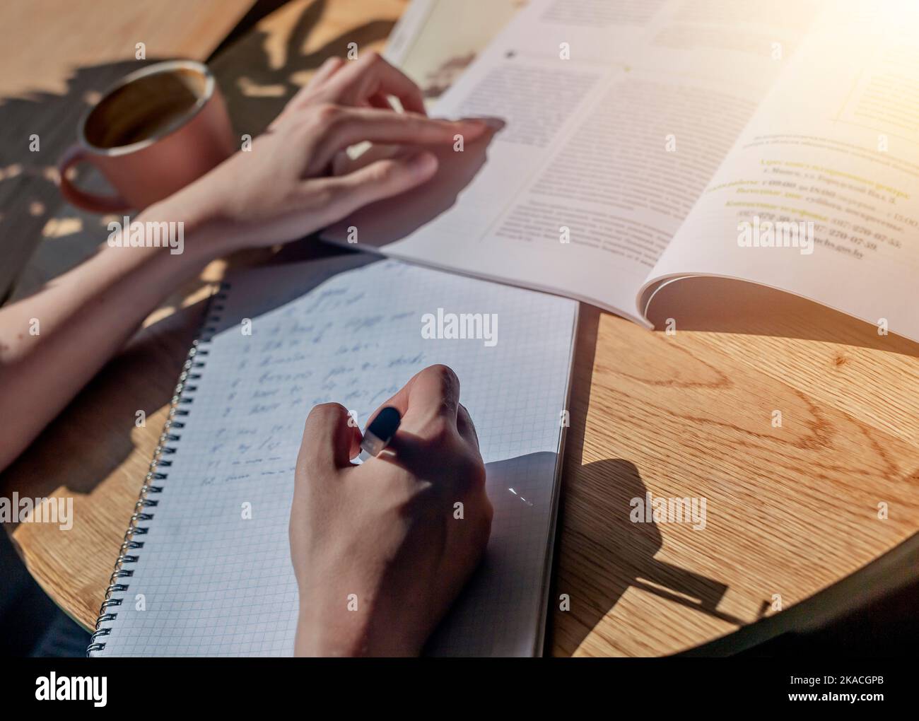 Women hand writing plans, taking notes in notepad and book on wood desk ...