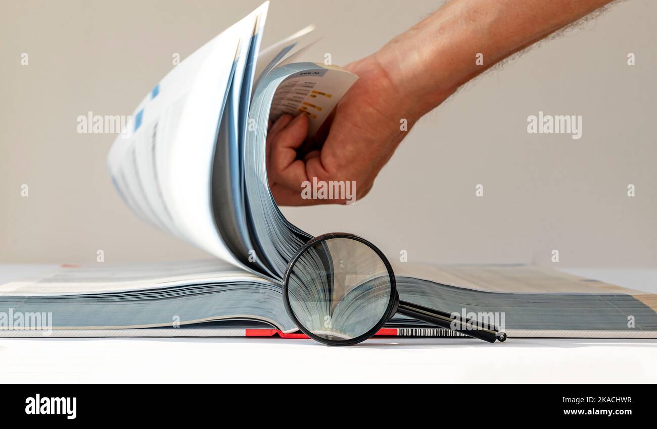 Technical book with turning pages and magnifier. Engineer research ...