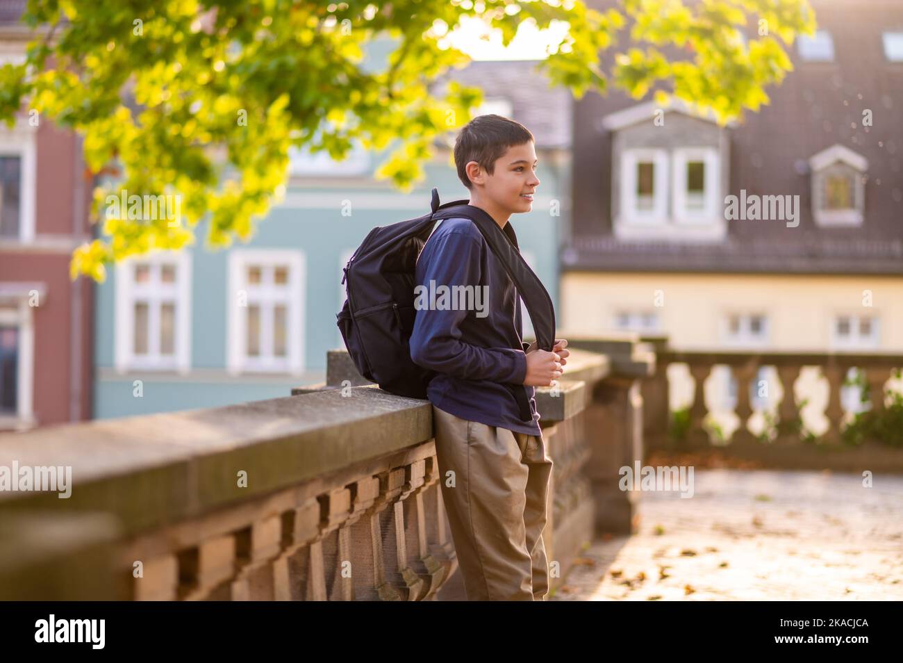Joyous teen with the backpack on his back standing outside Stock Photo ...