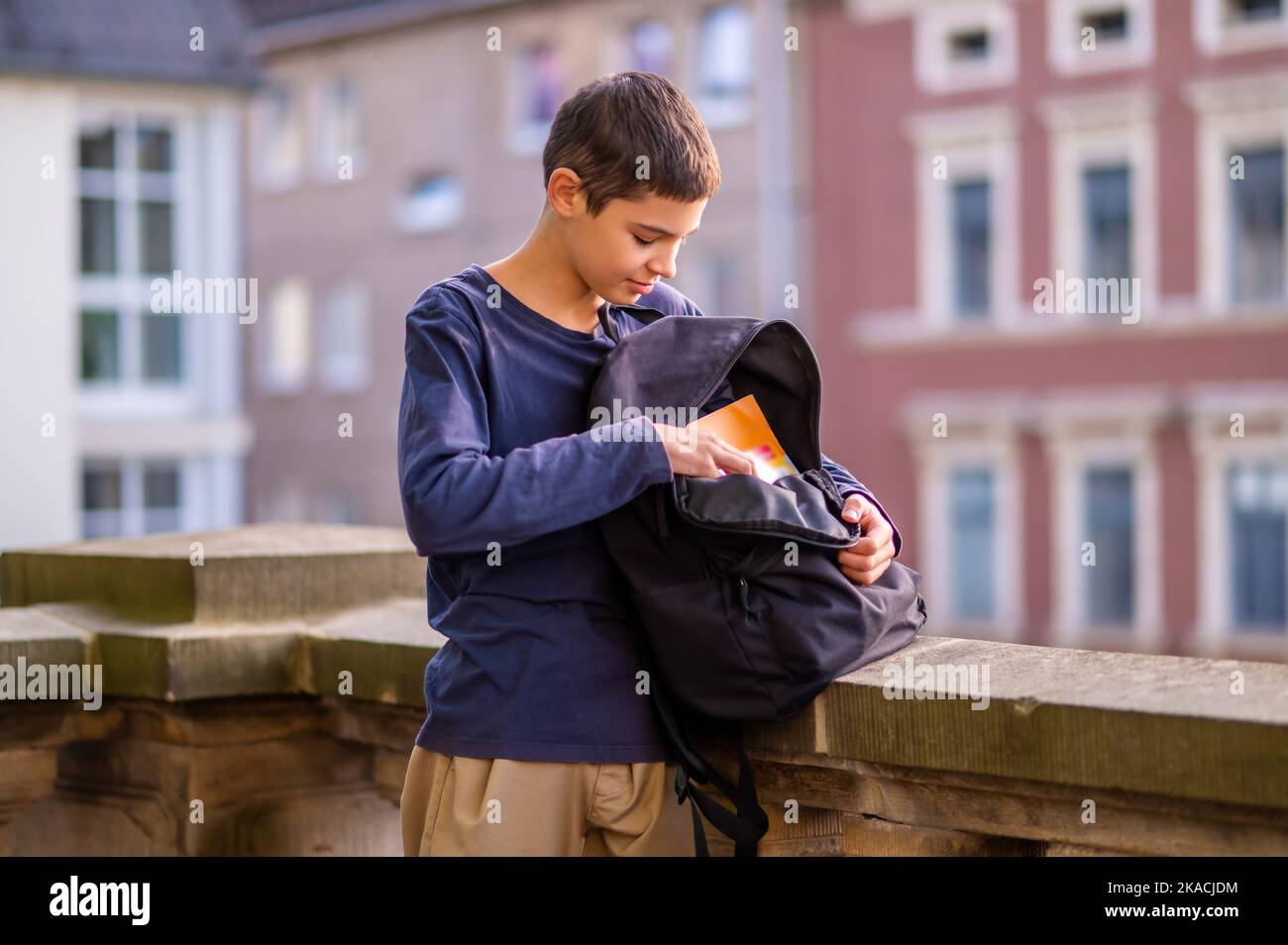 Concentrated boy packing his schoolbag after school Stock Photo - Alamy