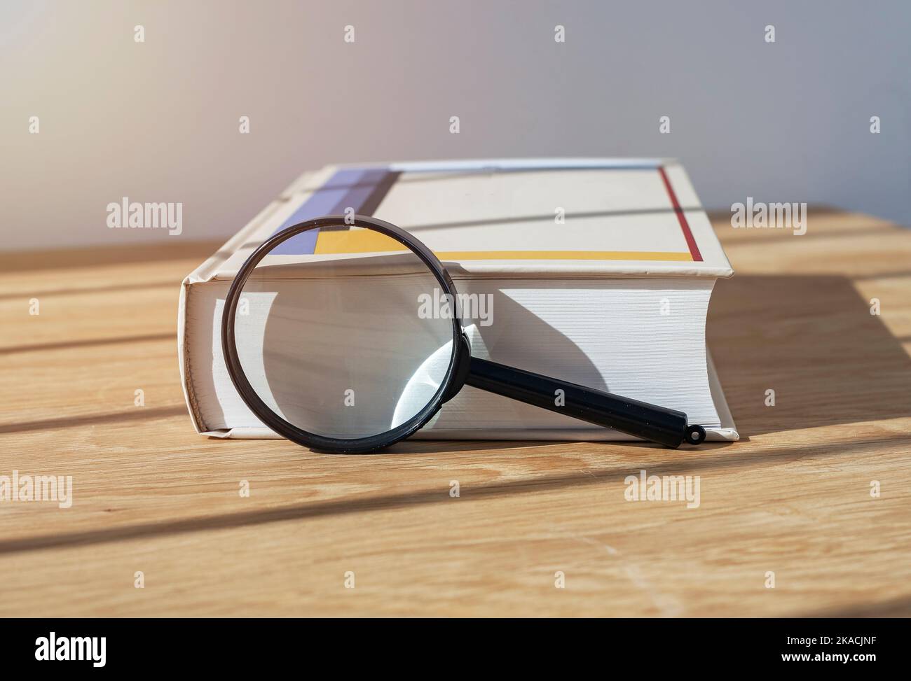 Magnifying lens with close thick book for study and reading Stock Photo ...