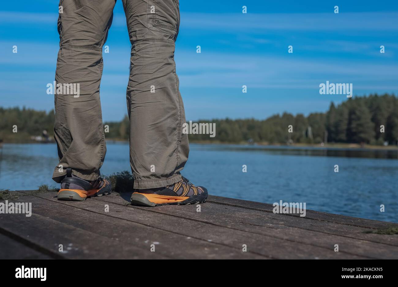 Fishermans legs on wood pier while fishing in summer Stock Photo - Alamy