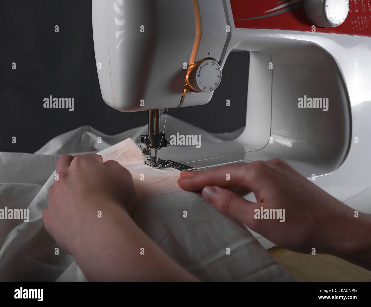Women hands at sewing machine during working process with cloth Stock ...