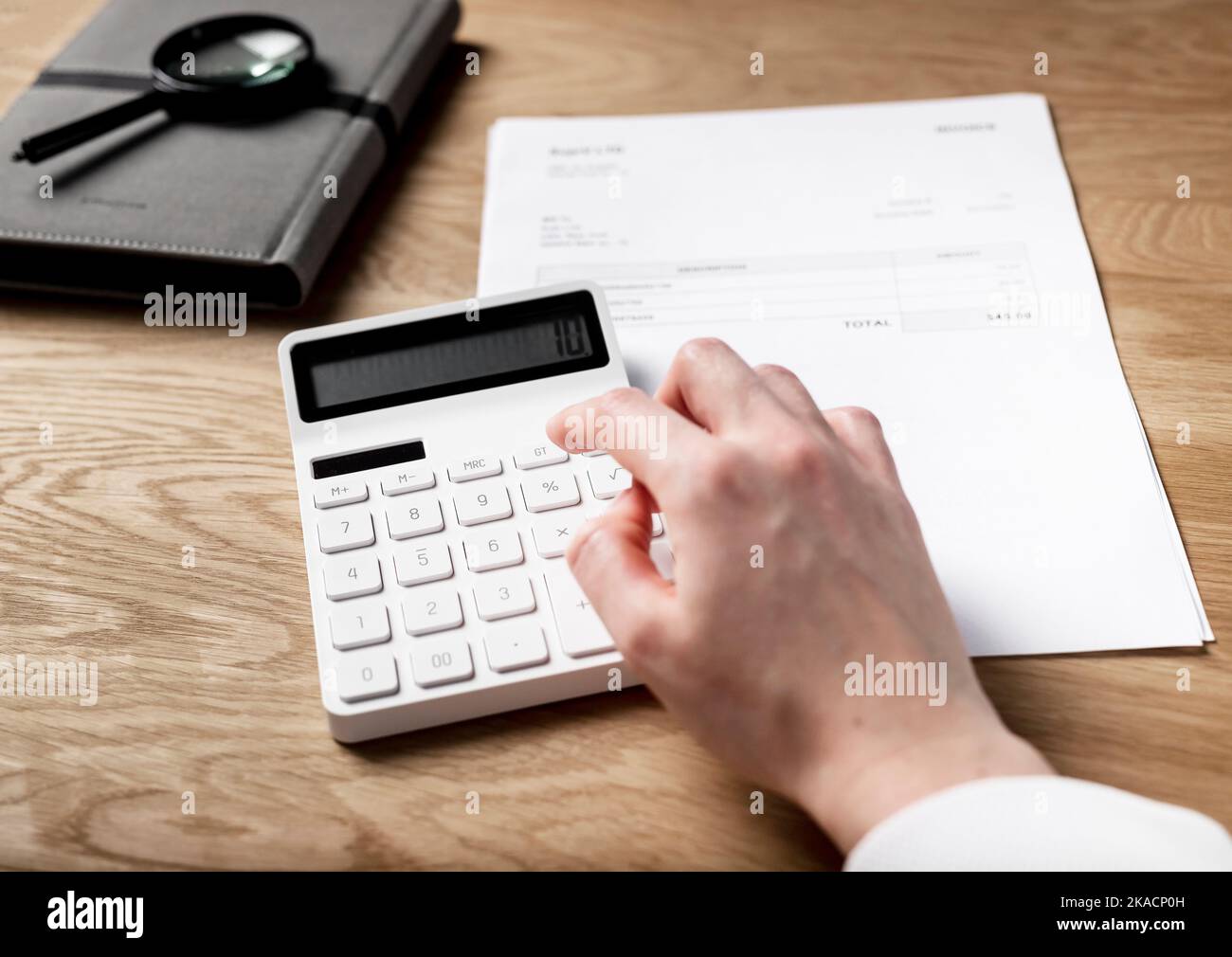 Business paper document and hand make calculations on calculator ...