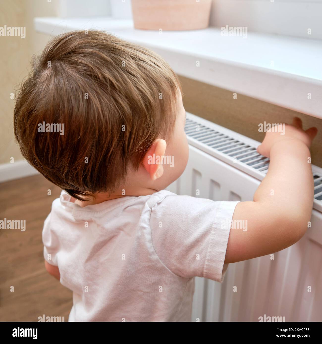 Toddler baby holding on to the radiator, child hand on the heating ...