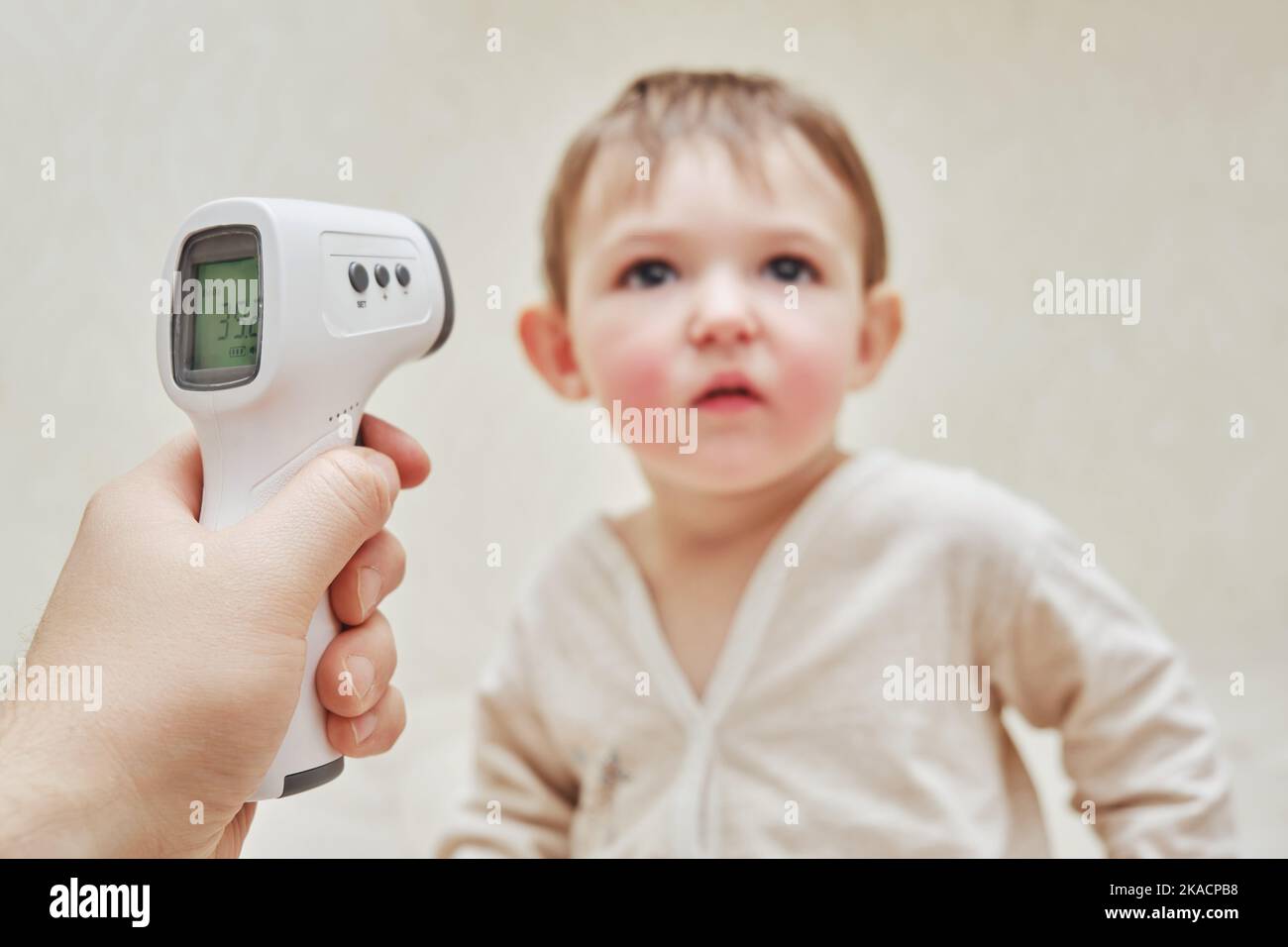 A man father measures the temperature of a sick toddler baby with a ...