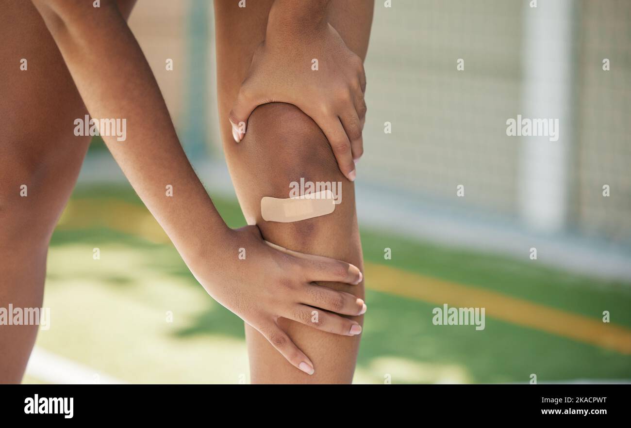 Woman athlete, knee pain and sport injury outdoor with bandaid with ...