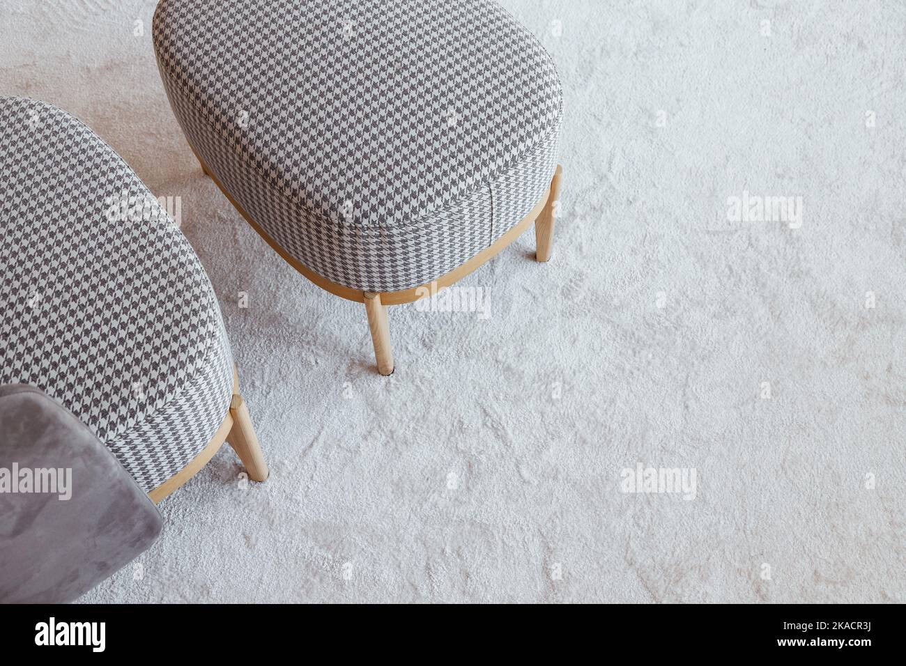 Checkered armchair with bench on wooden legs on a fluffy carpet, top ...