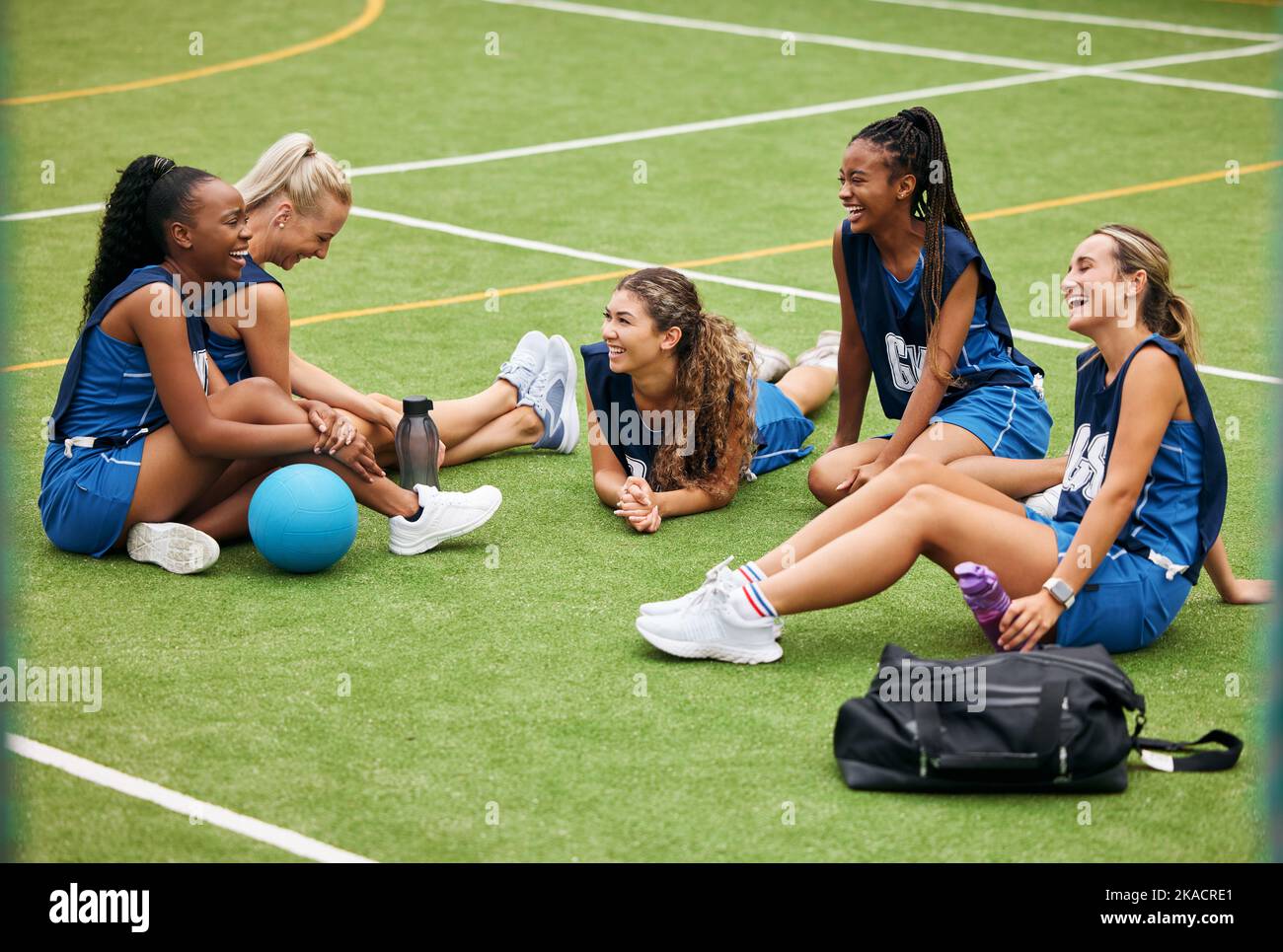 Sports, field and women team relax on grass with fitness gear talking ...