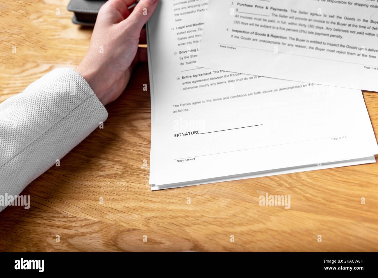Hand holding legal business agreement with empty place for signature ...