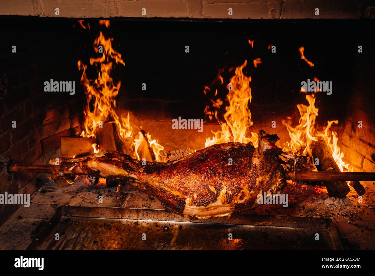 The lamb is cooked entirely on a spit on the fire. Cooking Stock Photo ...