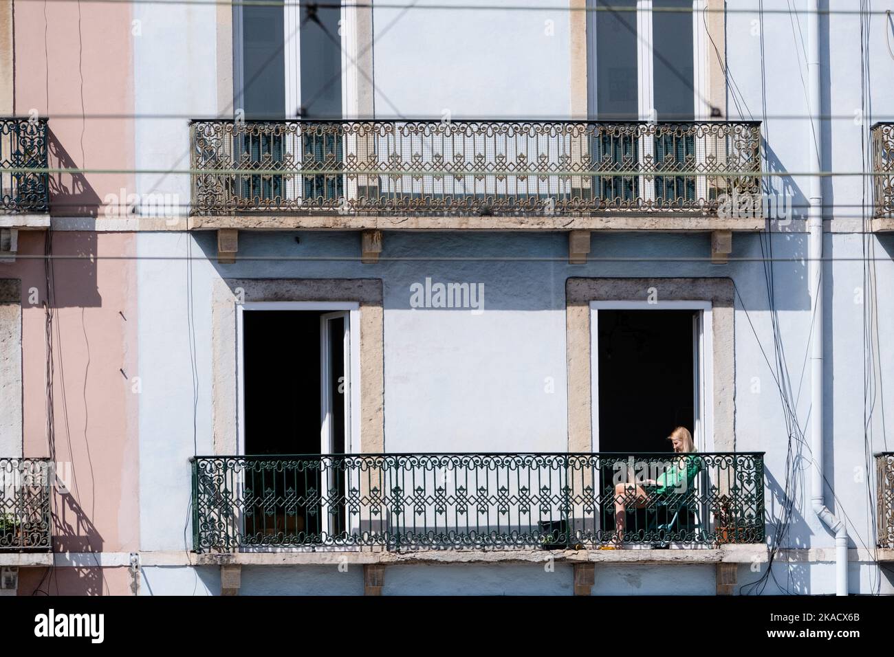 A woman works on a laptop on a balcony overlooking the Tejo Promenade ...