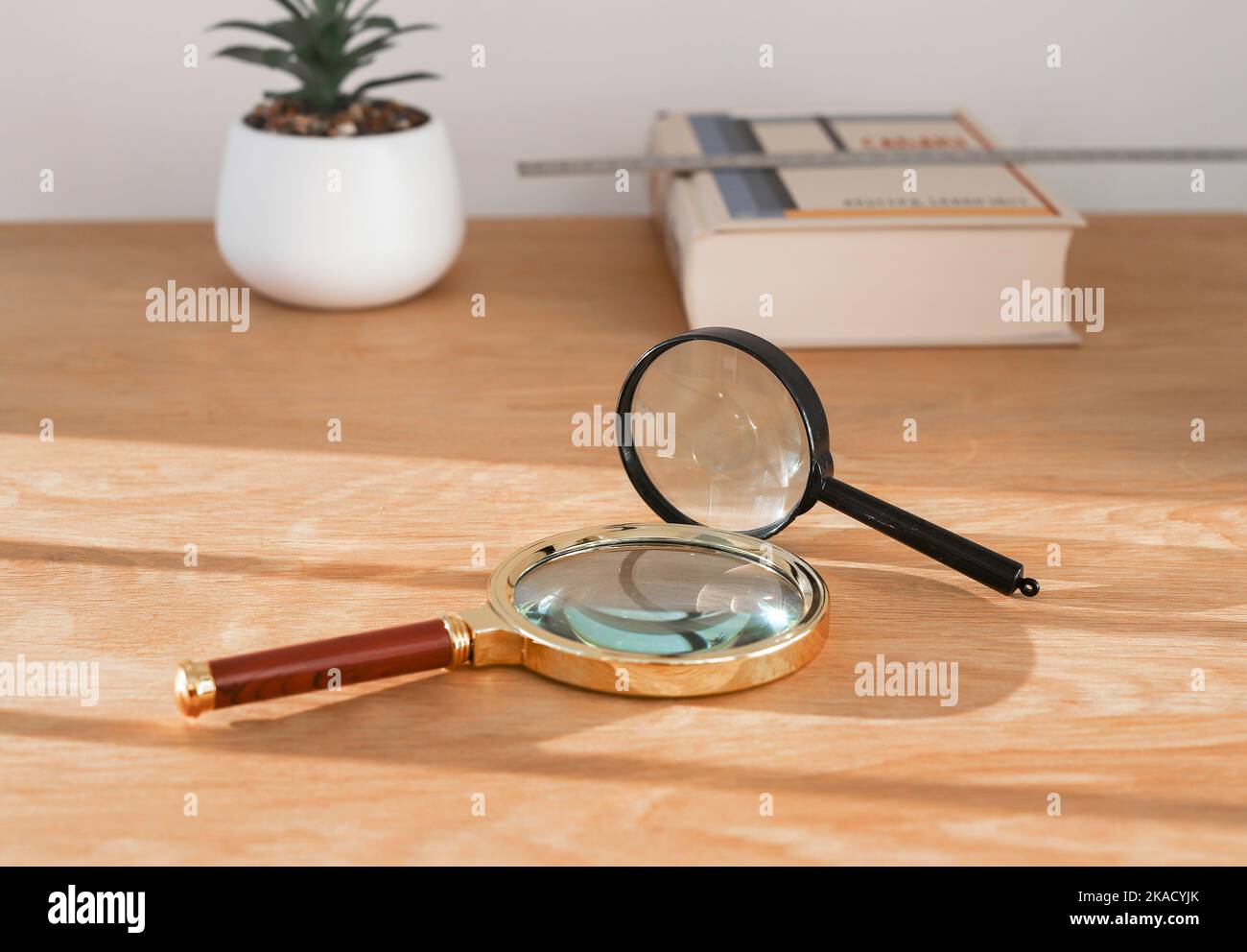Magnifying lenses on wood desk with book. Concept of exploration, study ...