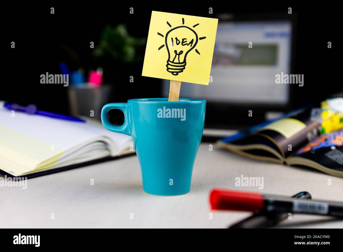 Light bulb doodle drawn on sticky note inside a cup of coffee at the ...