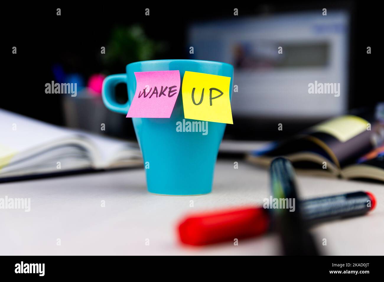 Sticky notes on a coffe cup at office desk. Wake up. Prepare for work ...