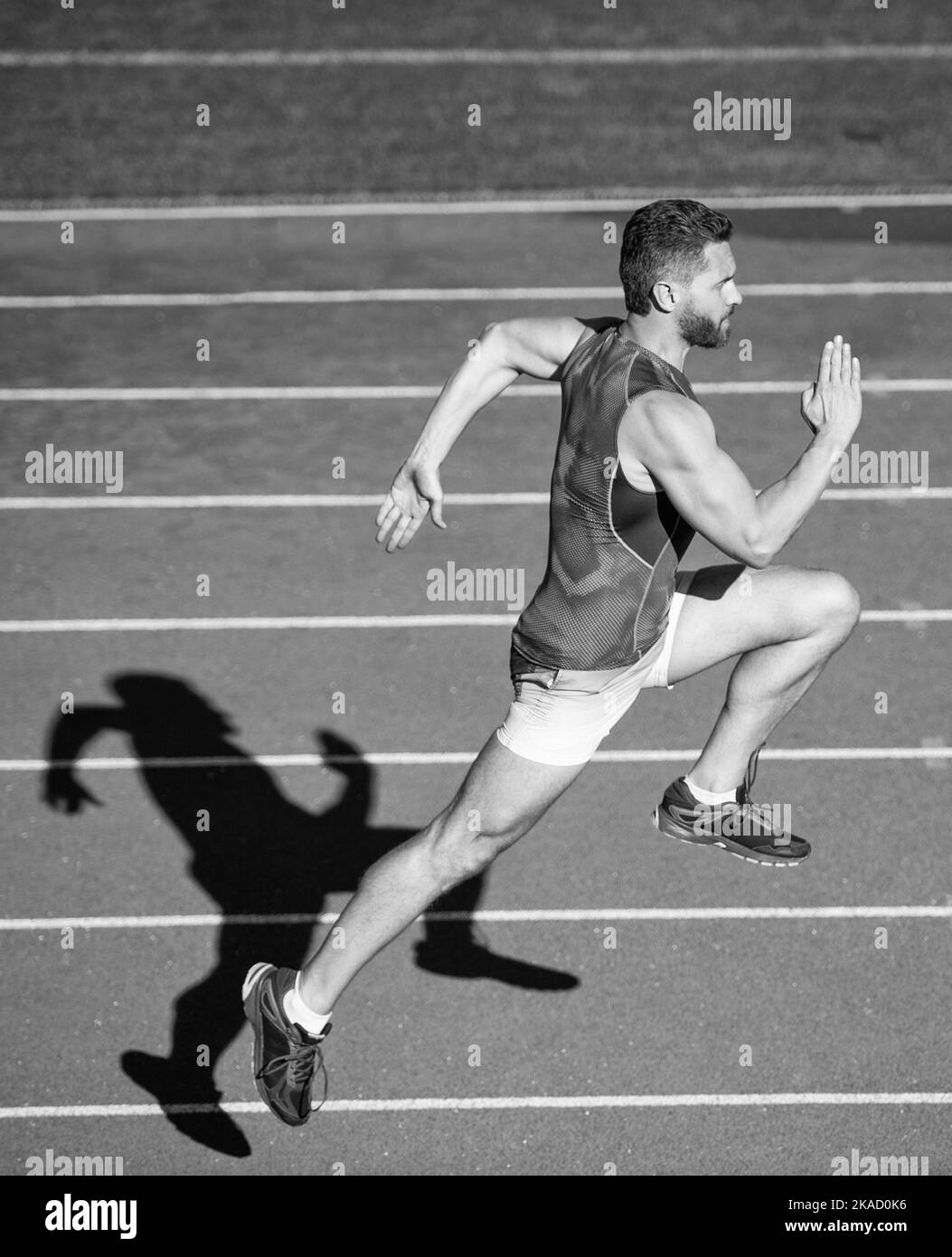energetic athletic muscular man runner running on racetrack at outdoor ...