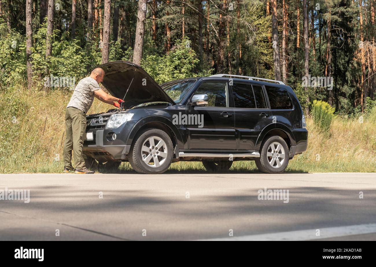 MINSK, BELARUS - October 30 2021 Driver standing and looking inside ...