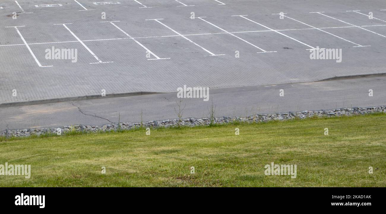 Large empty parking lot, with white markings for parking, grass in the ...