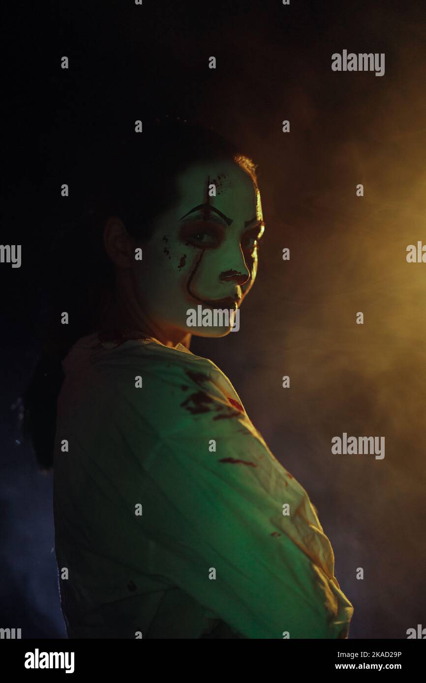 Young woman portrays bloodthirsty zombie with horror wounds on her face ...